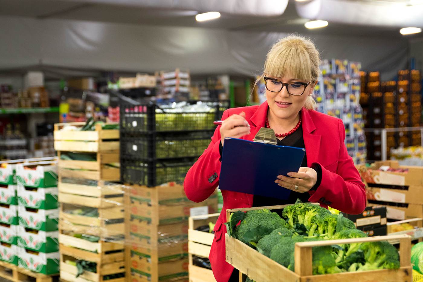 Woman checking vegetables in crates